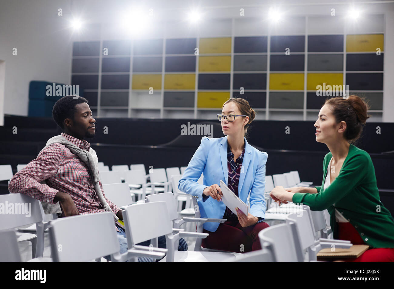 Three students discussing home assignment or lecture Stock Photo - Alamy
