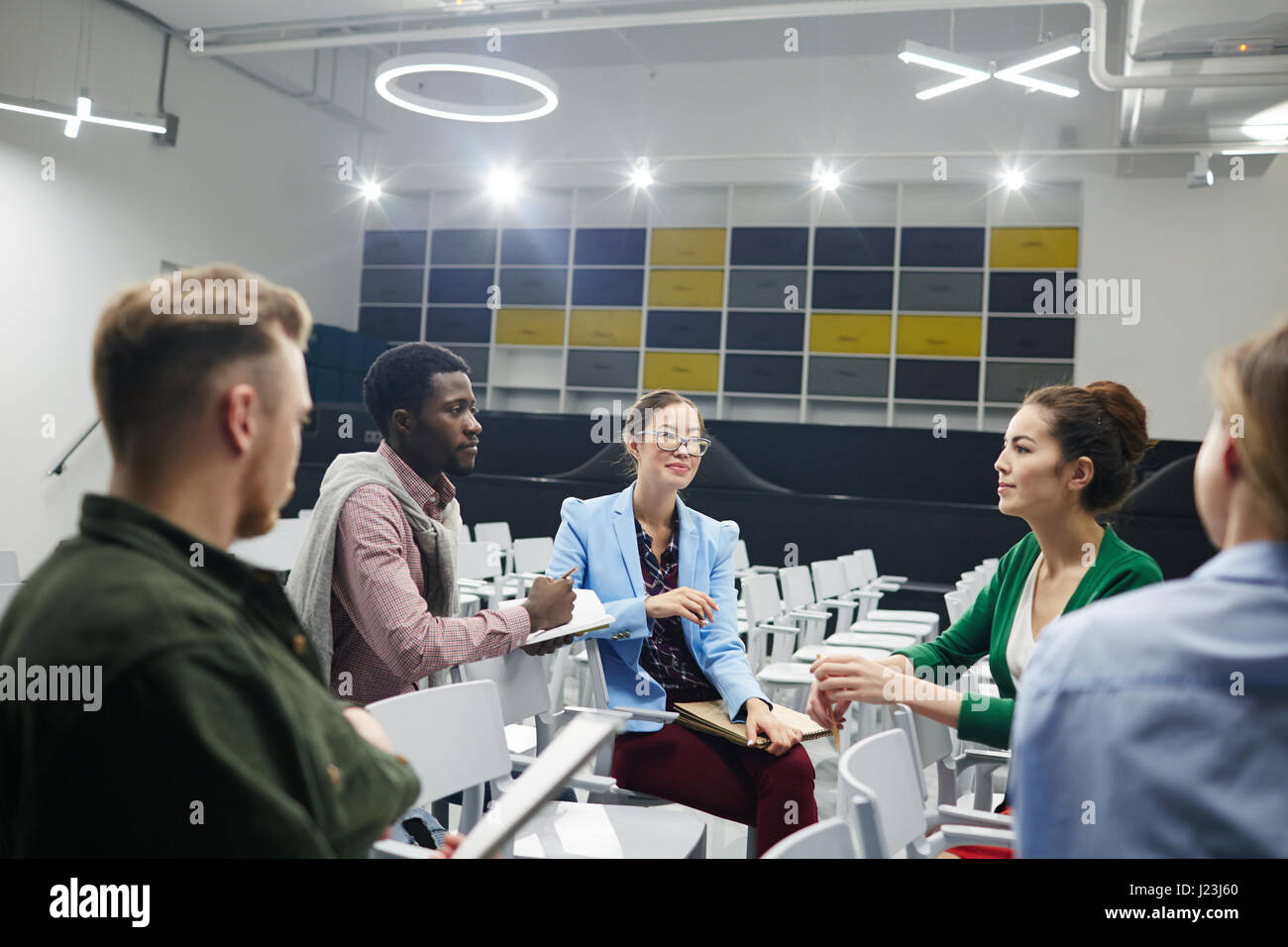 Groupmates discussing new lecture in conference hall Stock Photo - Alamy