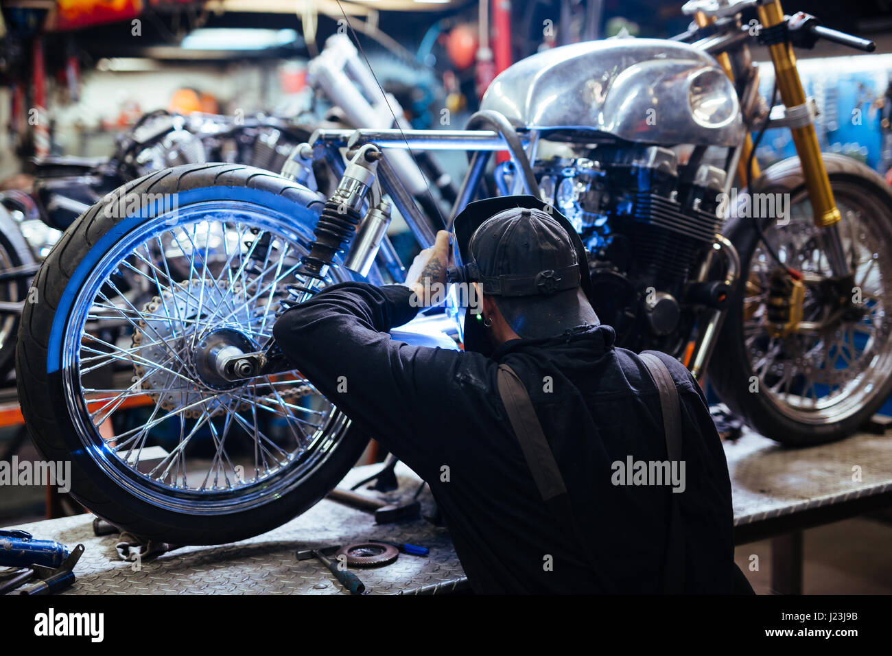 Back view portrait of tattooed man wearing protective mask welding ...
