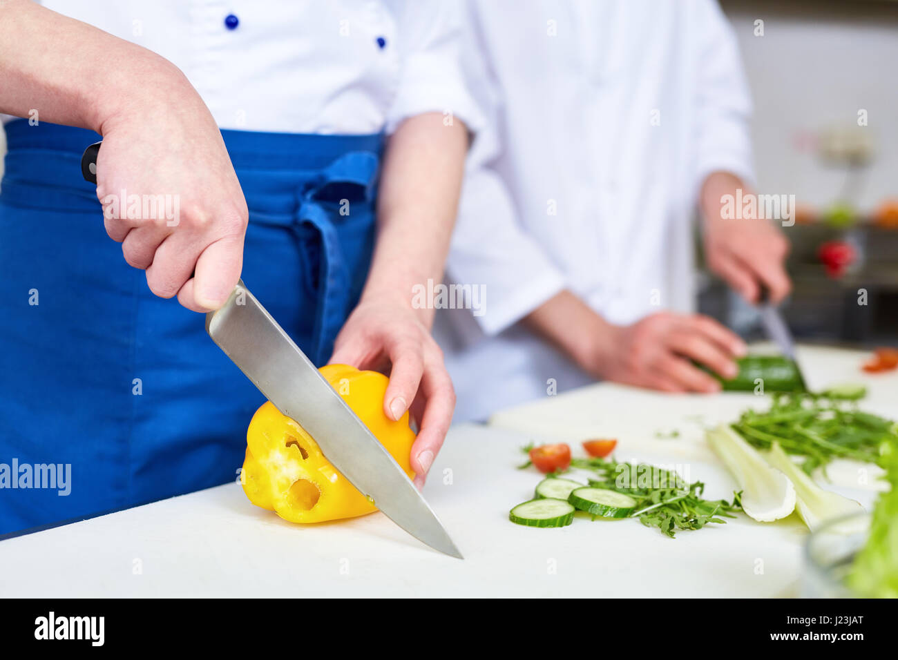 Trainee cutting fresh yellow pepper during cooking master-class Stock ...