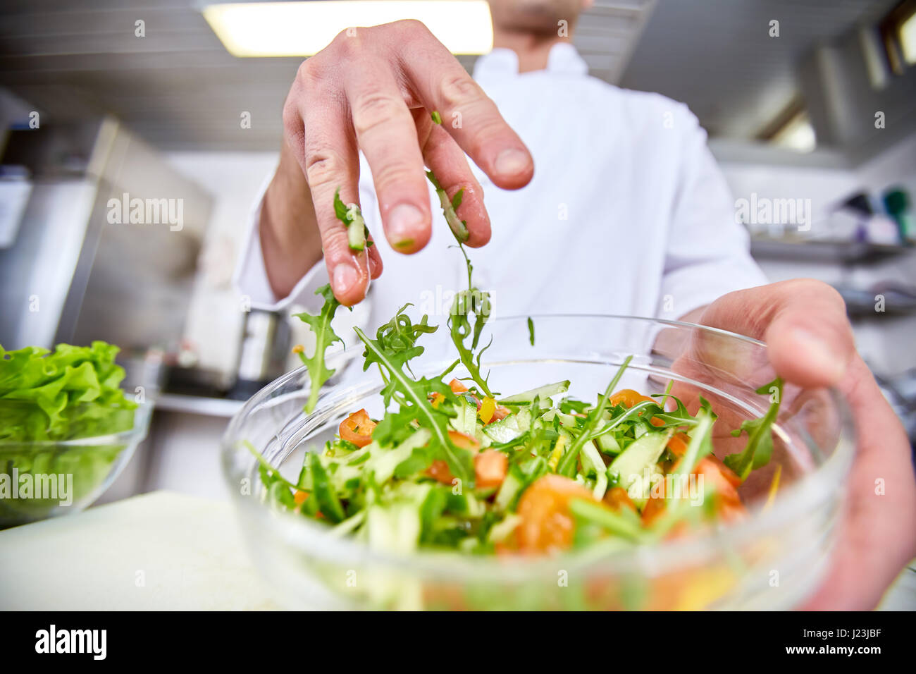 Professional chef mixing salad ingredients in bowl Stock Photo - Alamy