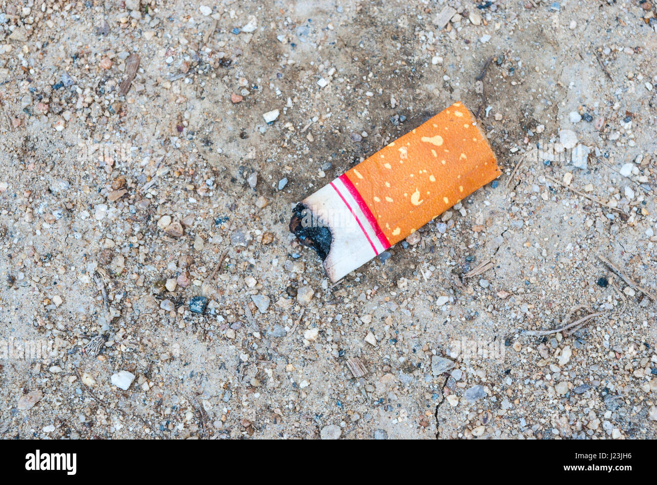Closeup to Short Cigarette Stub on Ground Stock Photo - Alamy