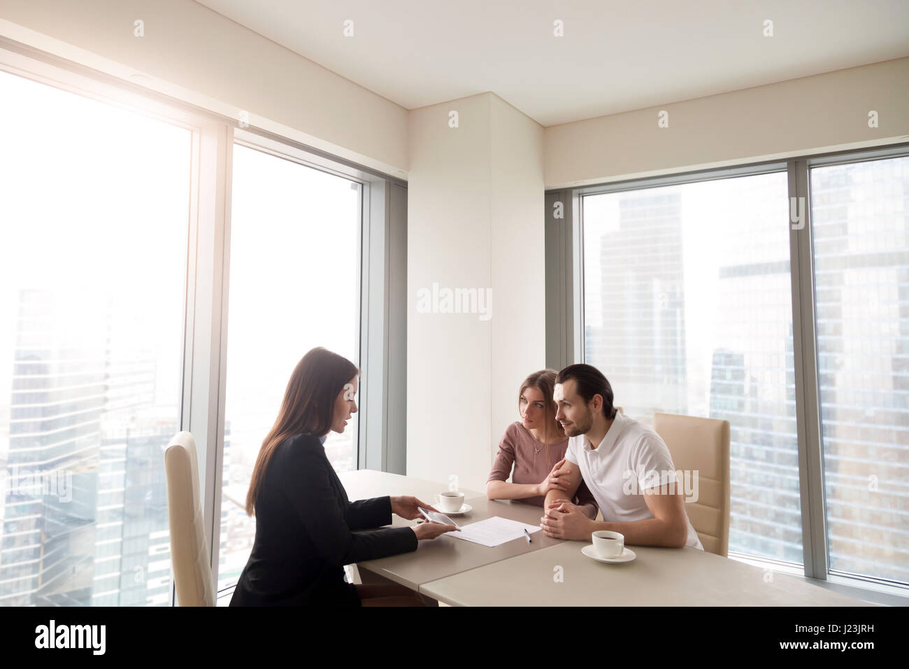 Young couple and real estate agent manager discussing contract a Stock ...