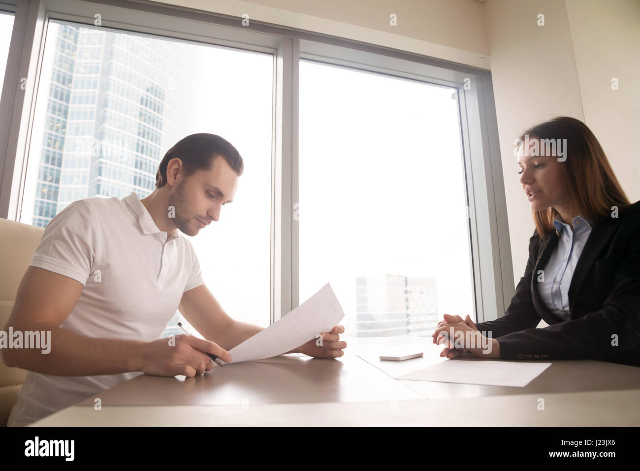 Got a job. Young man ready to sign working contract Stock Photo - Alamy