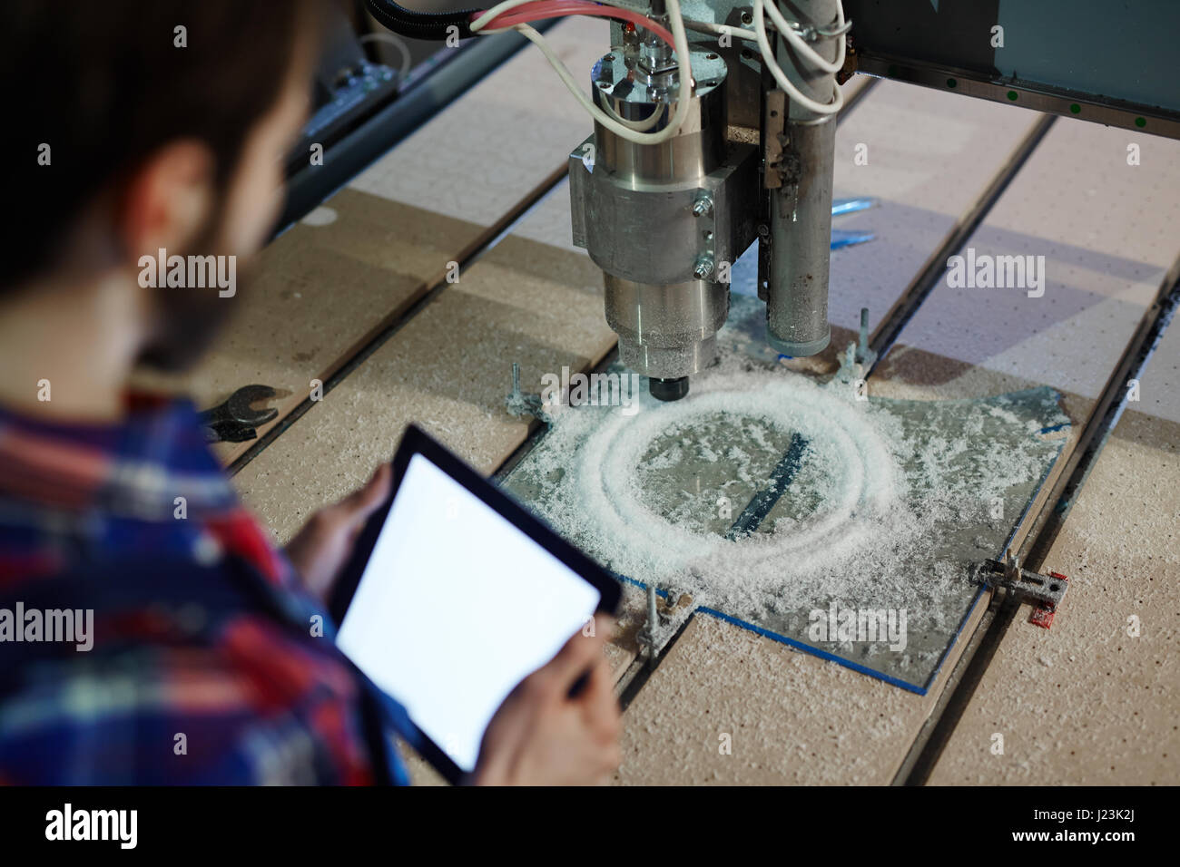 Workplace of technician with milling cutter, plywood sheet and glass ...