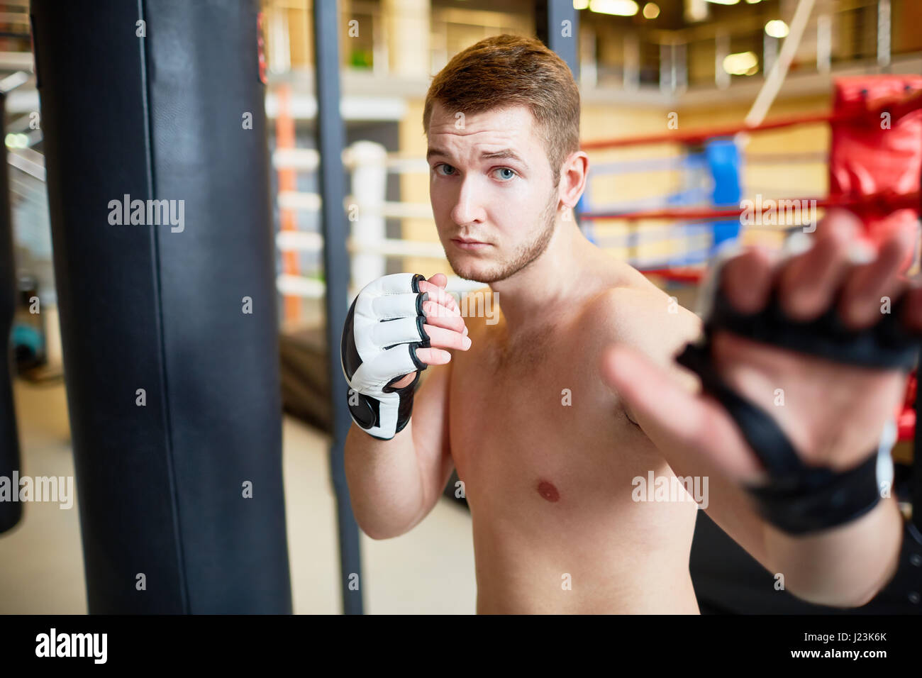 Portrait of determined shirtless man standing in fight pose and looking ...