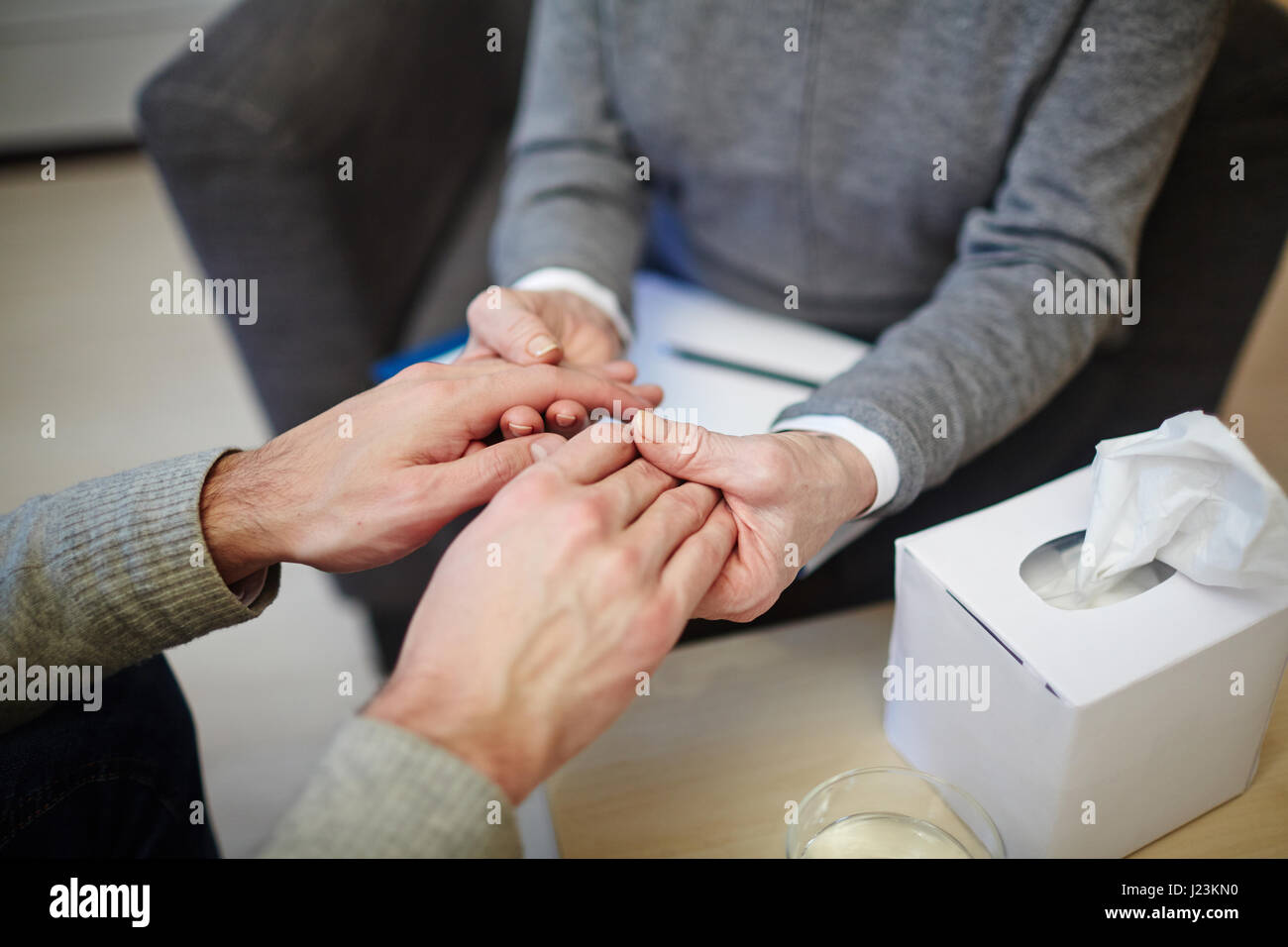 Psychiatrist giving helping hand to unhappy patient Stock Photo - Alamy