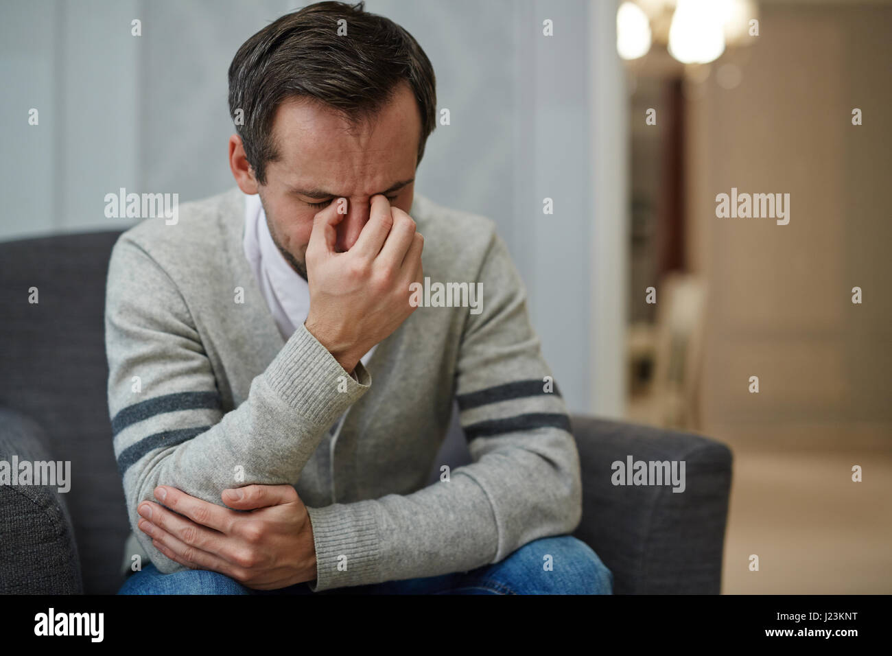 Desperate man crying during psychological session Stock Photo - Alamy