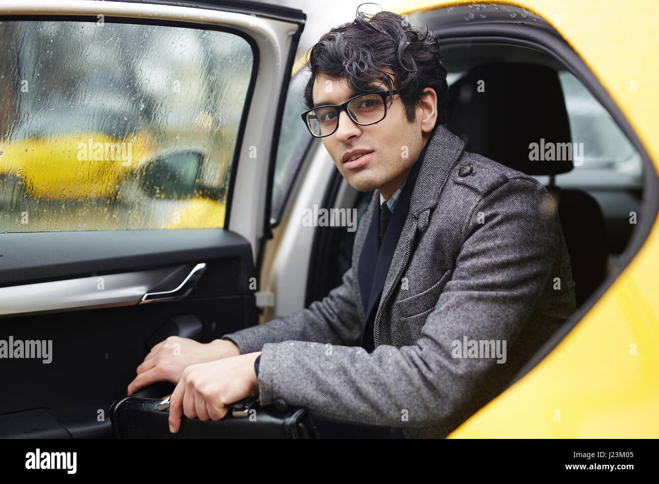 Confident ceo opening taxi cab door and getting out of it Stock Photo ...