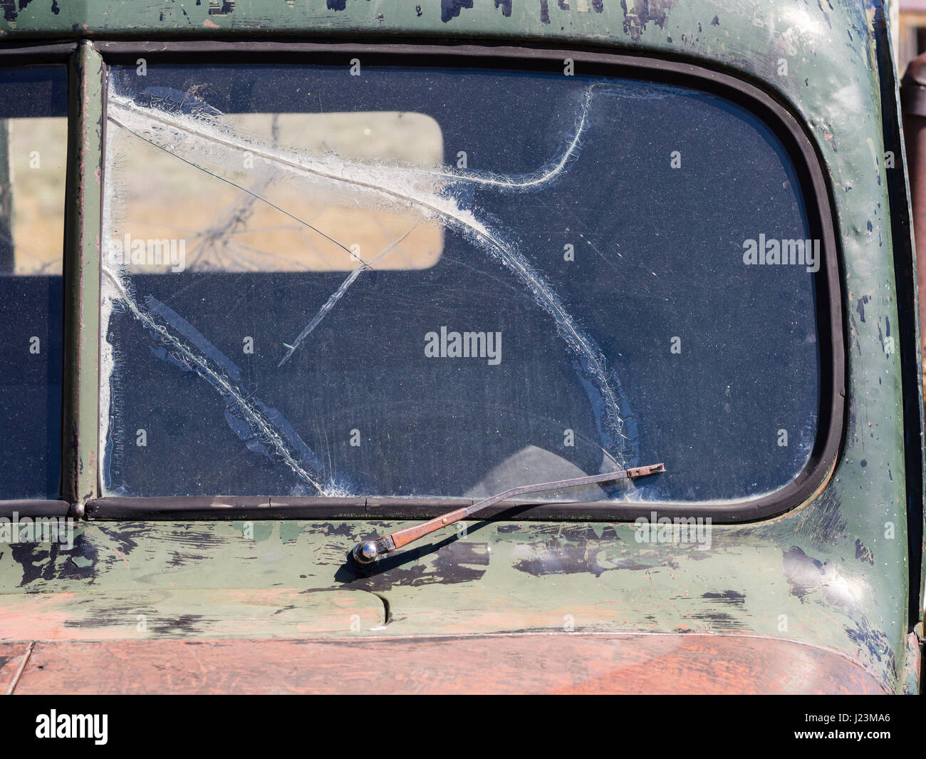 Cracked windshield of a rusty abandoned pickup truck car wreck, left ...