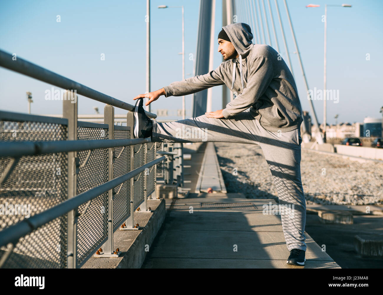 Handsome athlete man doing stretching exercise, preparing for workout ...