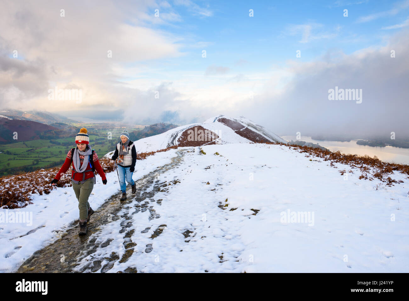 Fell walkers on Cat Bells in late autumn snow. Lake District National ...
