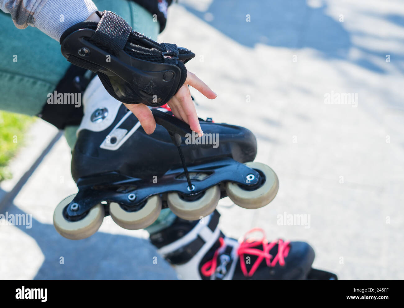 Roller girl unscrewing wheels on roller Skates with Allen key Stock ...