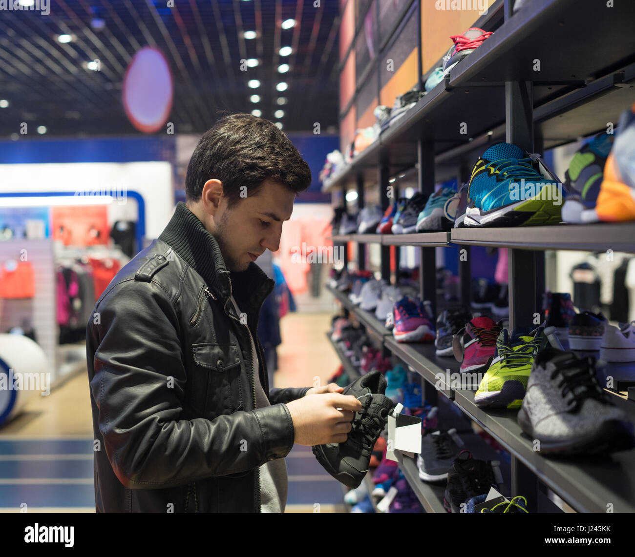 young male customer choosing sneakers Stock Photo - Alamy
