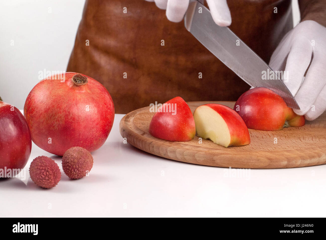 Chef cutting an apple on a wooden board with the help of sharp knife ...