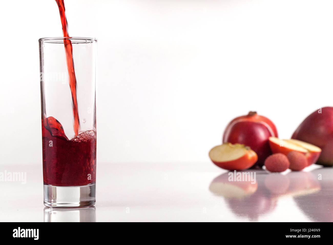 Flow of red juice pouring into a glass. Composition of fruits Stock ...