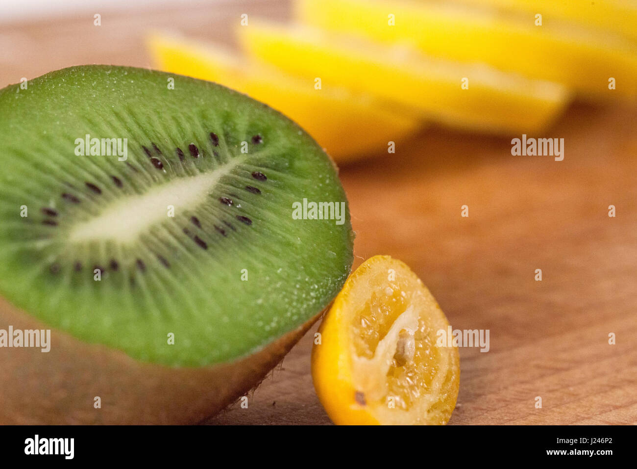 Close-up of fruits on a wooden cutting board. Kiwi and sliced lemon ...