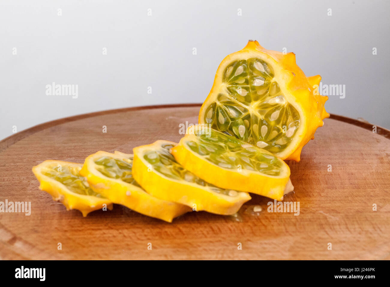 Kiwano melon cut pn a wwoden cutting board. Tropical fruit Stock Photo ...