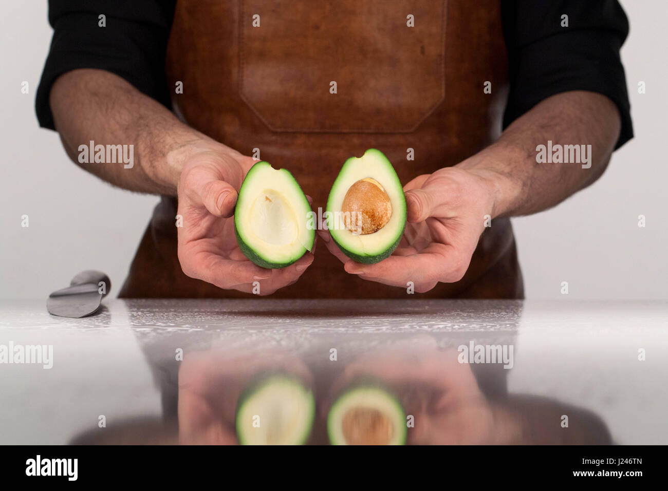 Man hoding hanves of cut fresh avocado Stock Photo - Alamy
