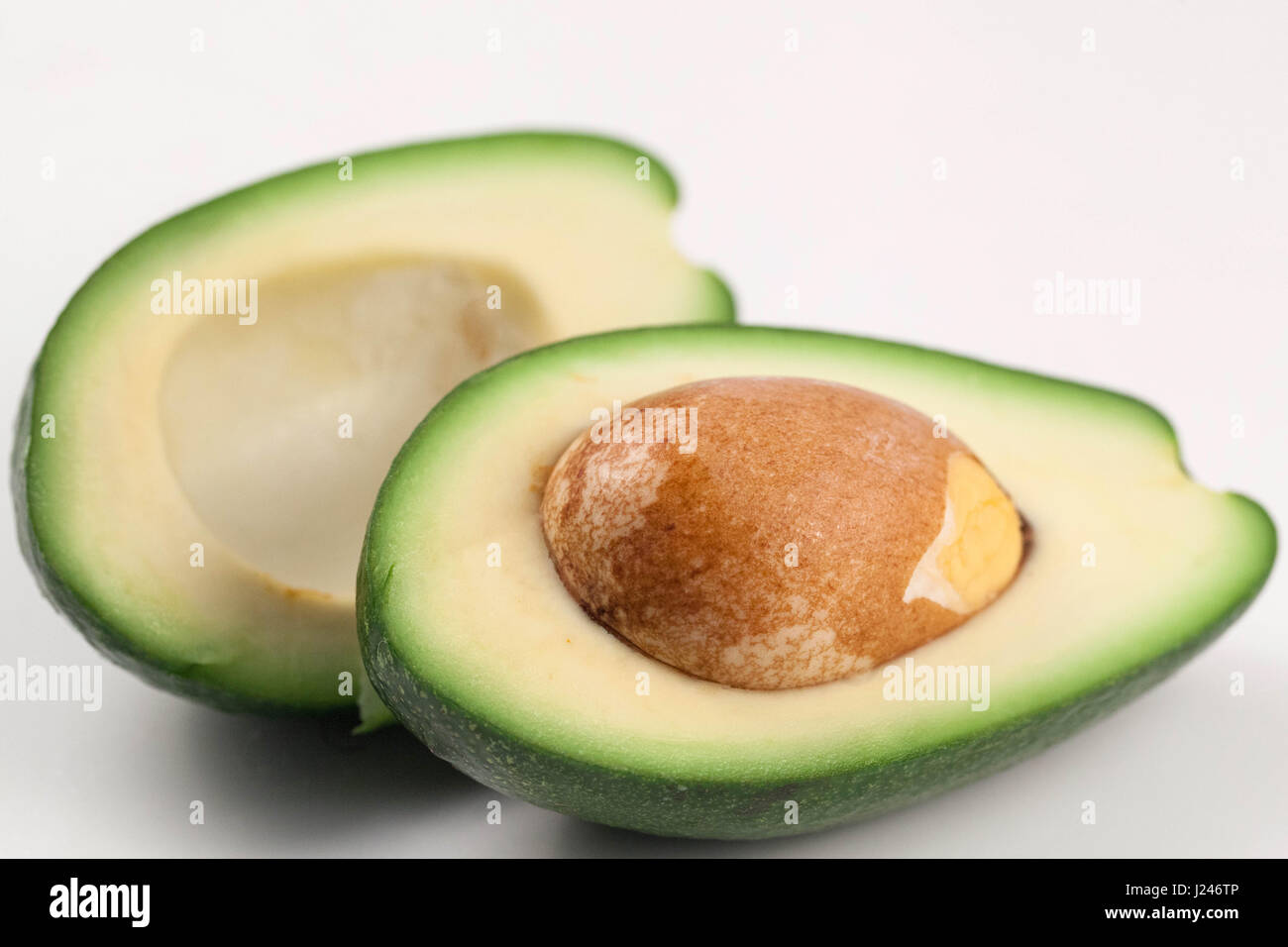 Two slices of avocado isolated on a white background. One slice with ...