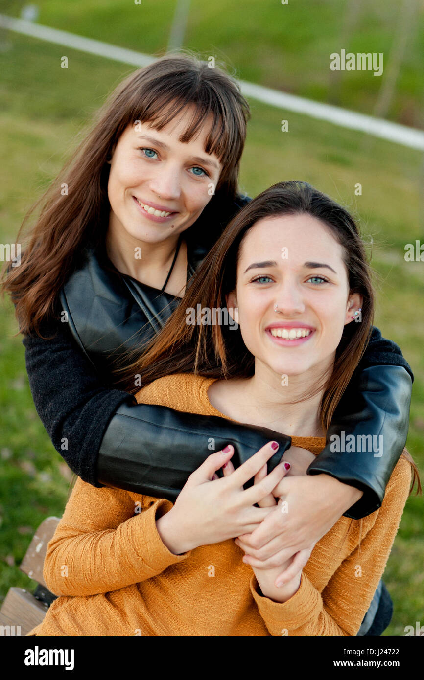 Outdoor portrait of two happy sisters relaxed in a park Stock Photo - Alamy