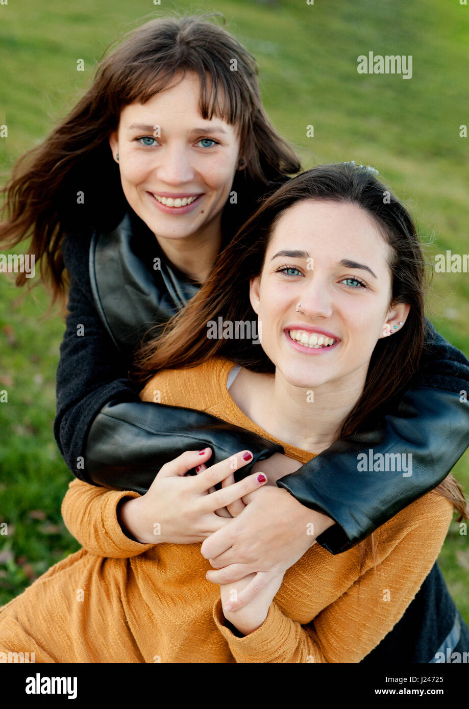 Outdoor portrait of two happy sisters relaxed in a park Stock Photo - Alamy