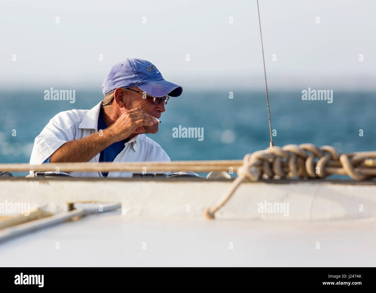 Skipper on a sea-going catamaran used for sunset cruises off the coast ...