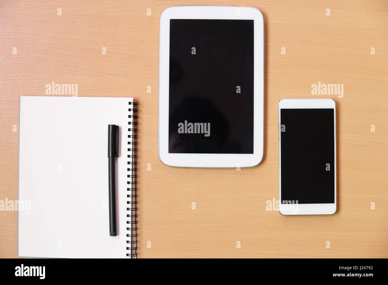 Smart phone with Taplet , notebook paper , black pen on wooden office ...