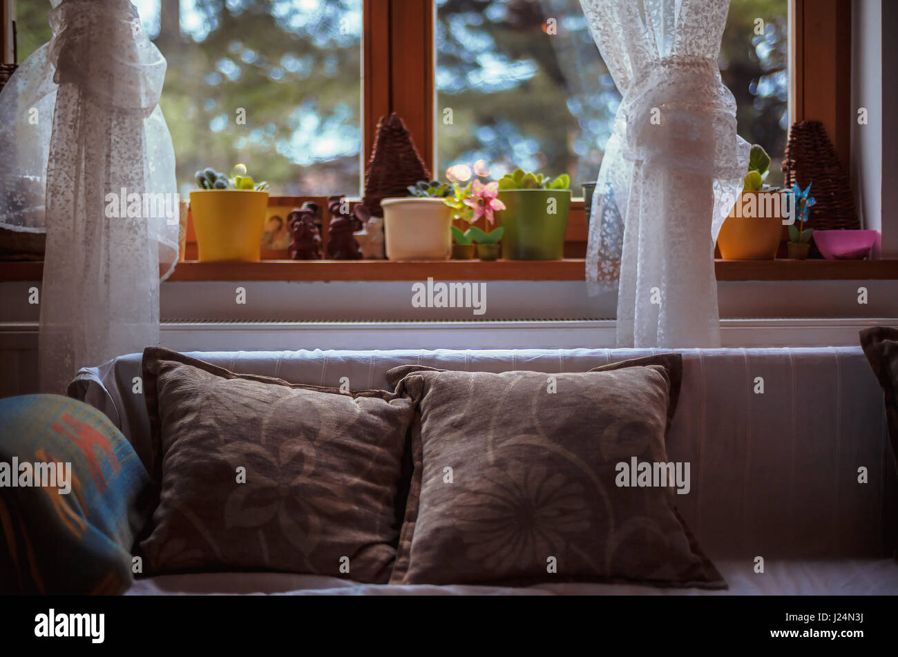 Calm scene of a bed in front of window with white decorative curtains ...