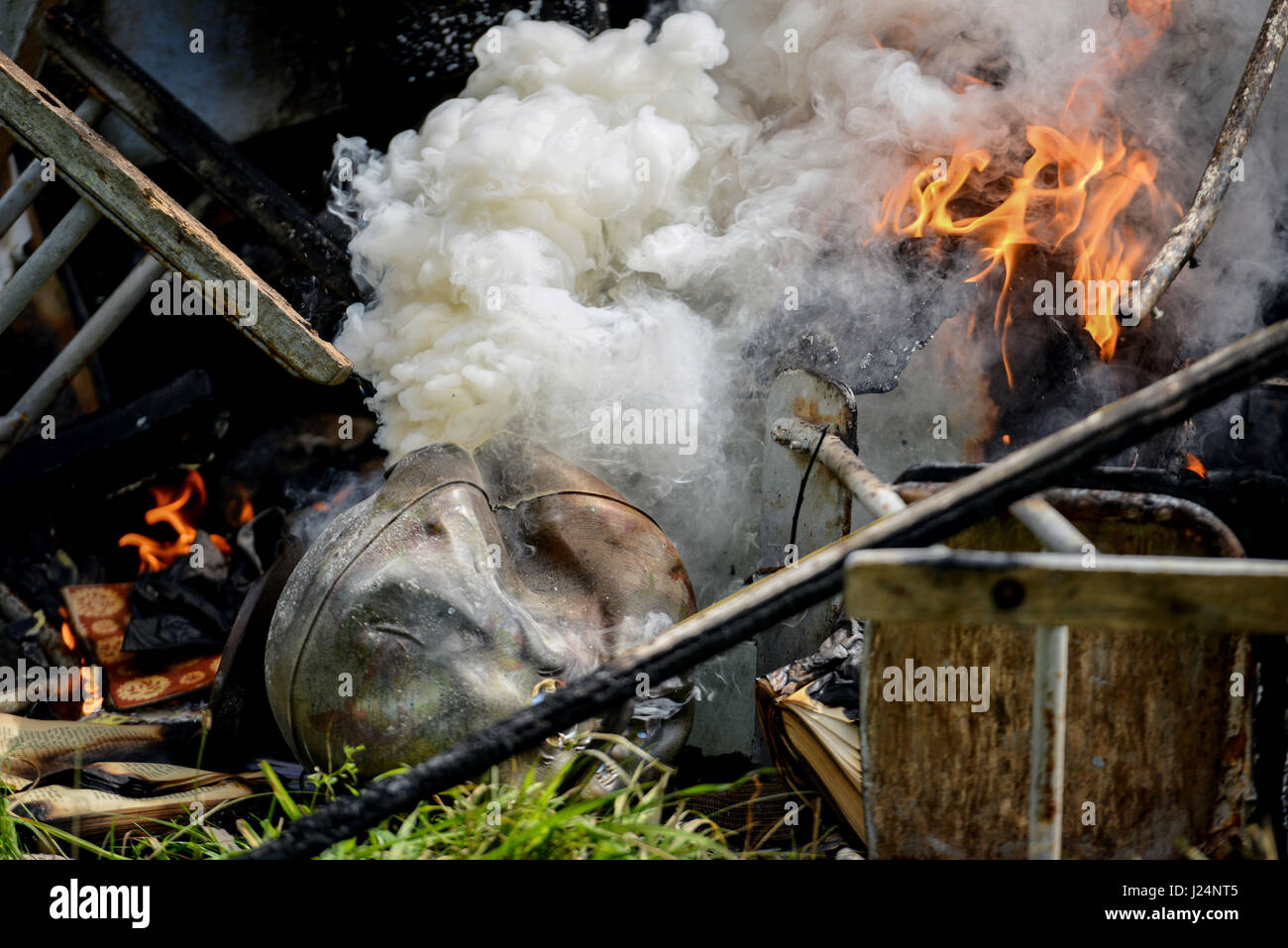 In the grass lying fire damaged things and books Stock Photo - Alamy