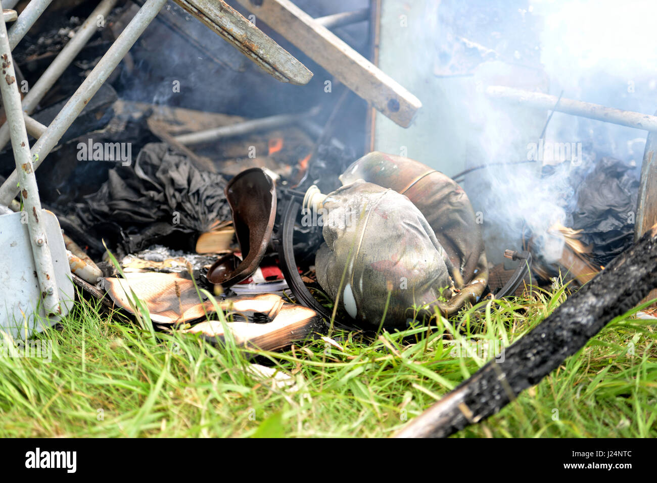 In the grass lying fire damaged things and books Stock Photo - Alamy