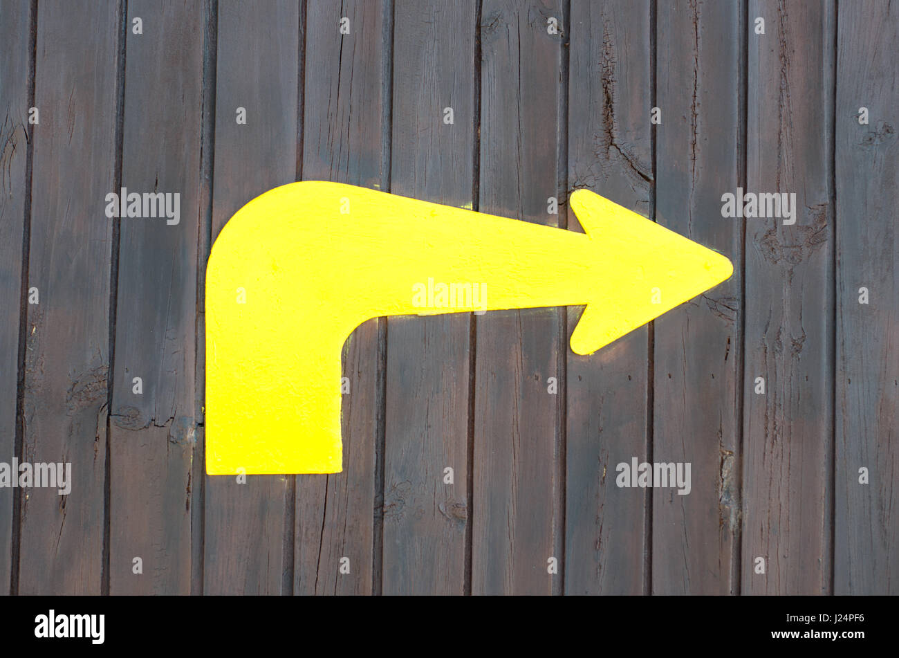 Yellow Arrow on a wooden background Stock Photo - Alamy
