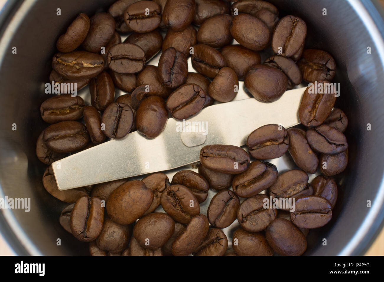 Coffee beans inside coffee grinder closeup Stock Photo - Alamy