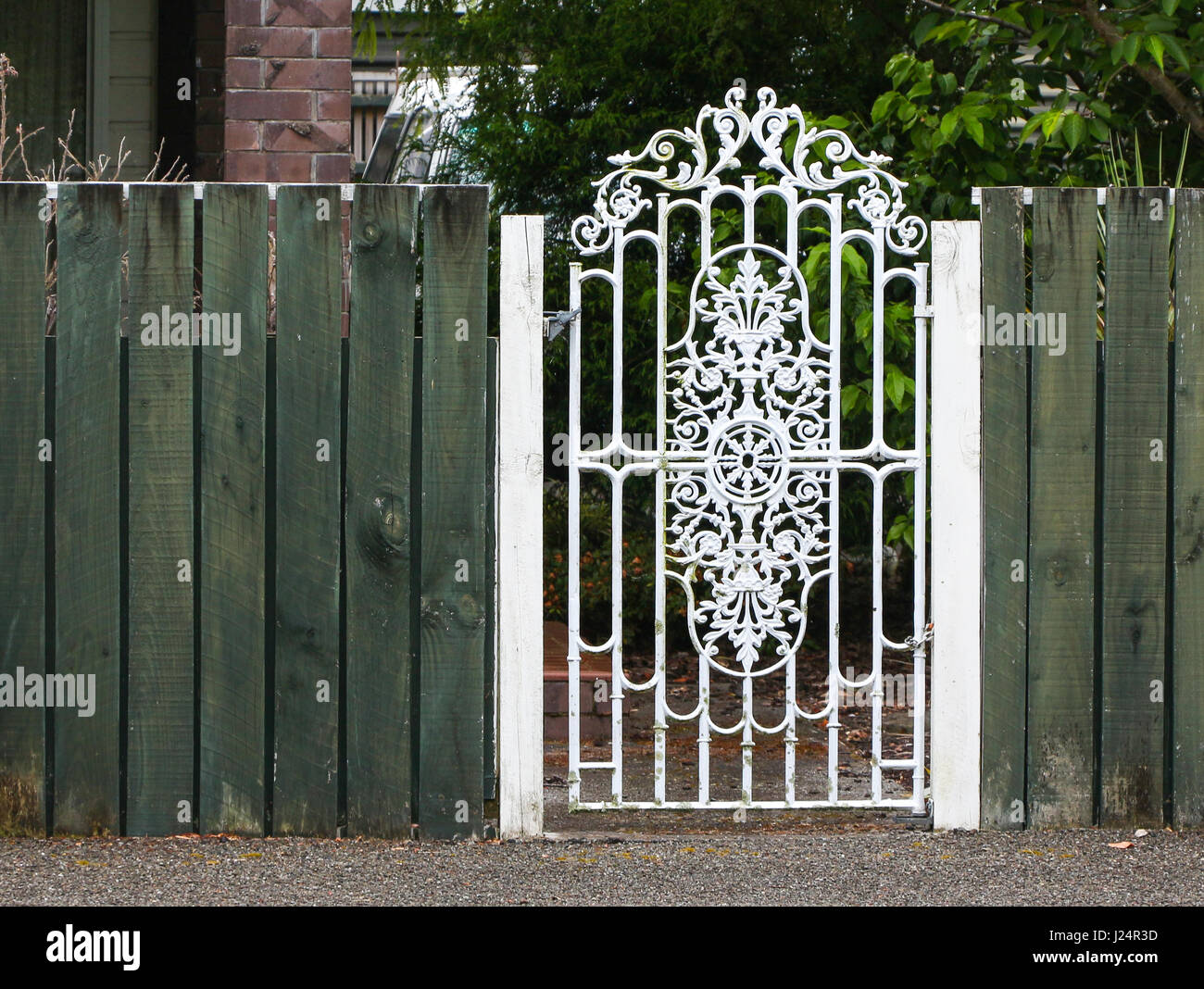 Metal white gate in a green wooden fence Stock Photo - Alamy
