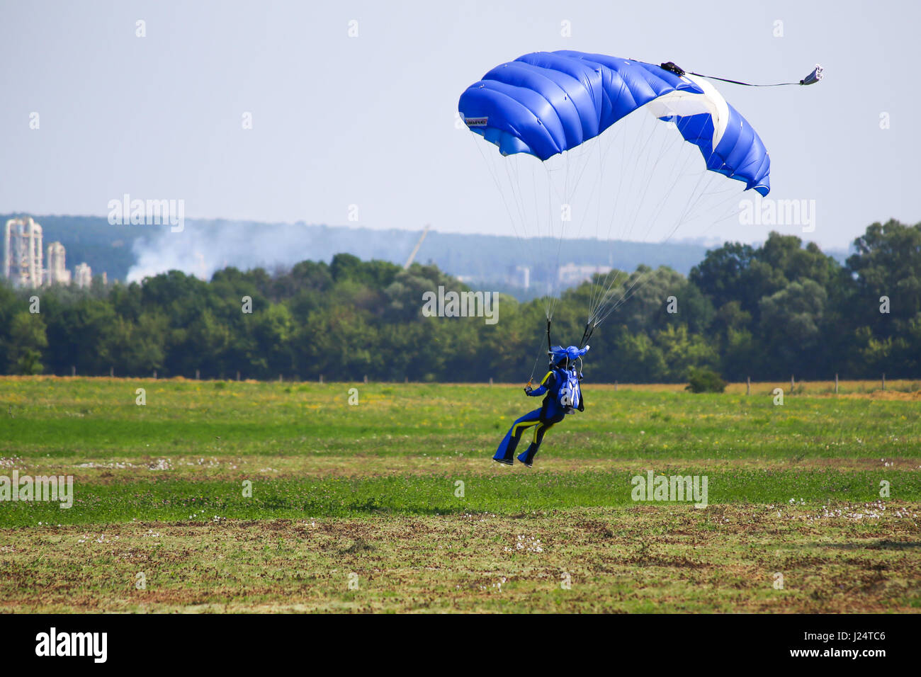 The skydiver landing on grass airfield Stock Photo - Alamy