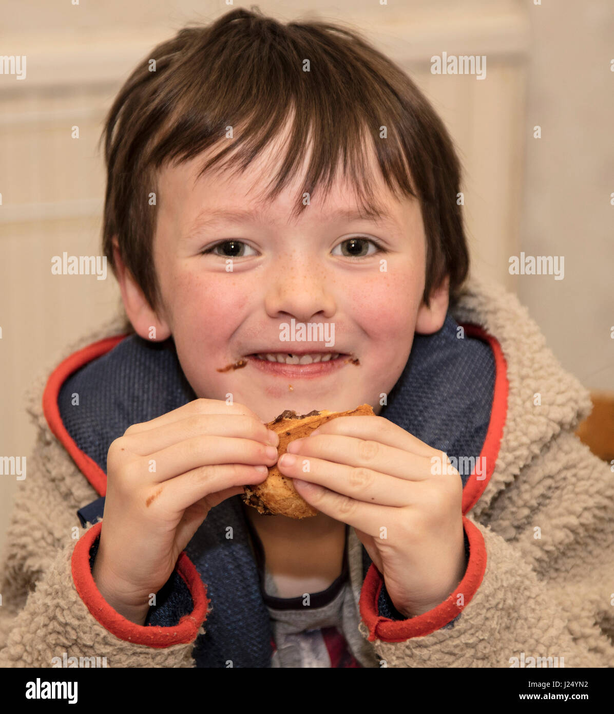 Young boy eating hot cross buns for breakfast Stock Photo - Alamy
