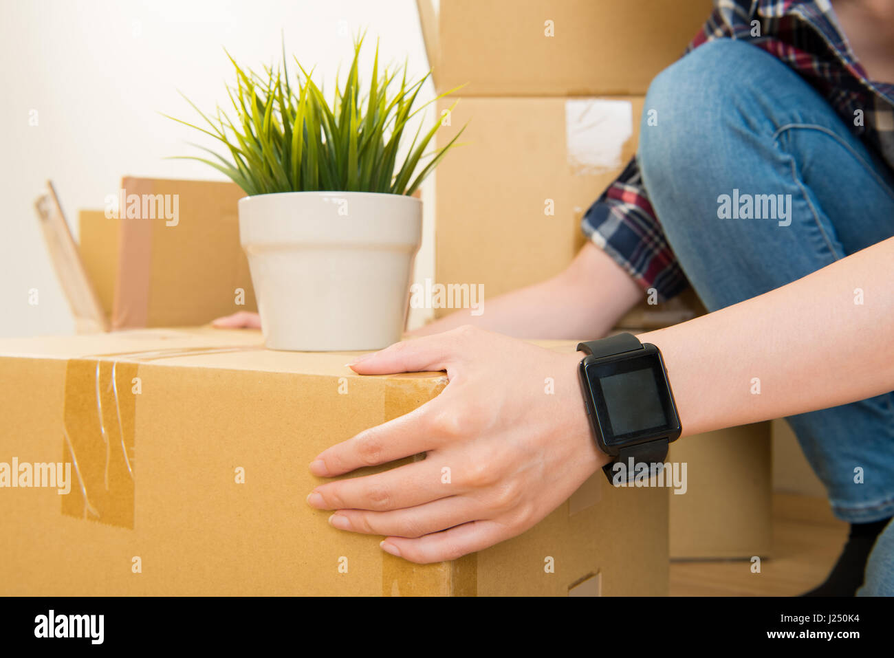 beautiful woman wearing smart watch on hand moving to new house ...