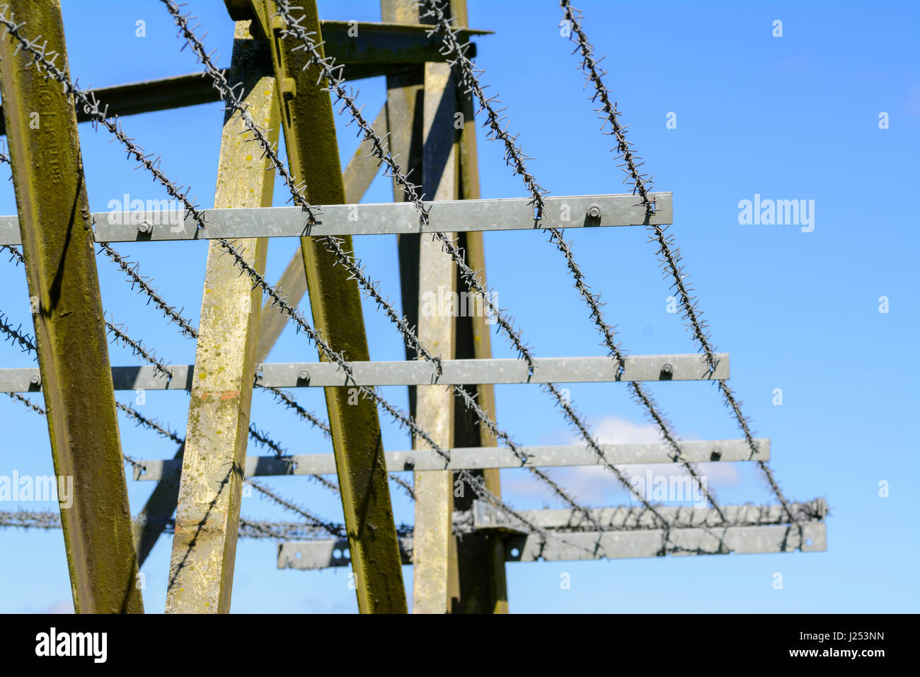Barbed security wire on an electricity pylon Stock Photo - Alamy
