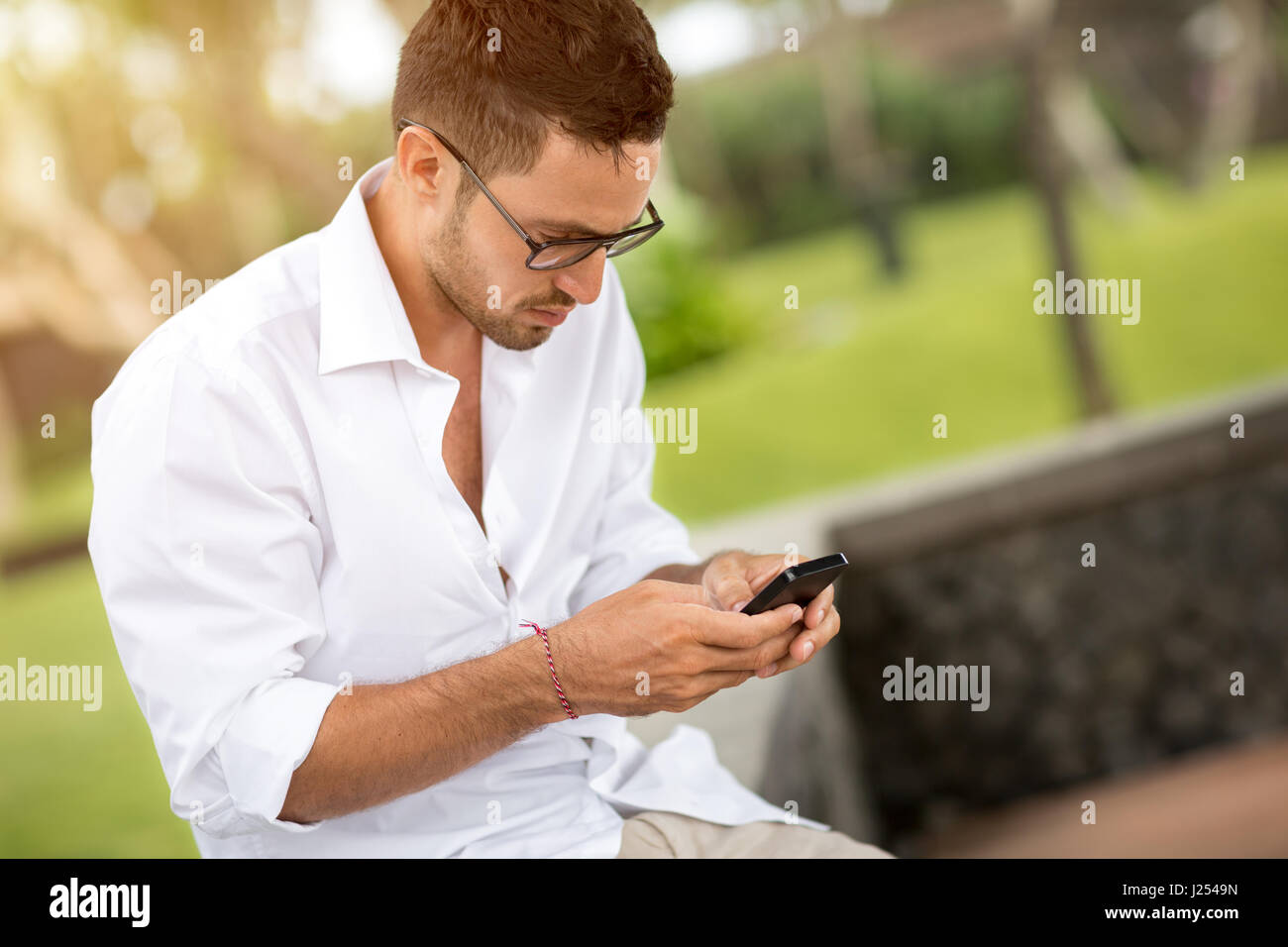 Handsome man reading message on smart phone Stock Photo - Alamy
