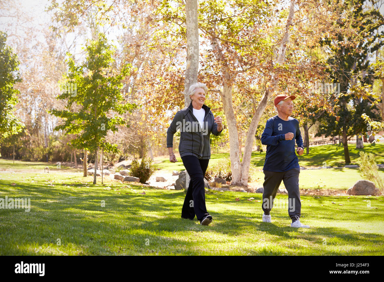 Side View Of Senior Couple Power Walking Through Park Stock Photo - Alamy