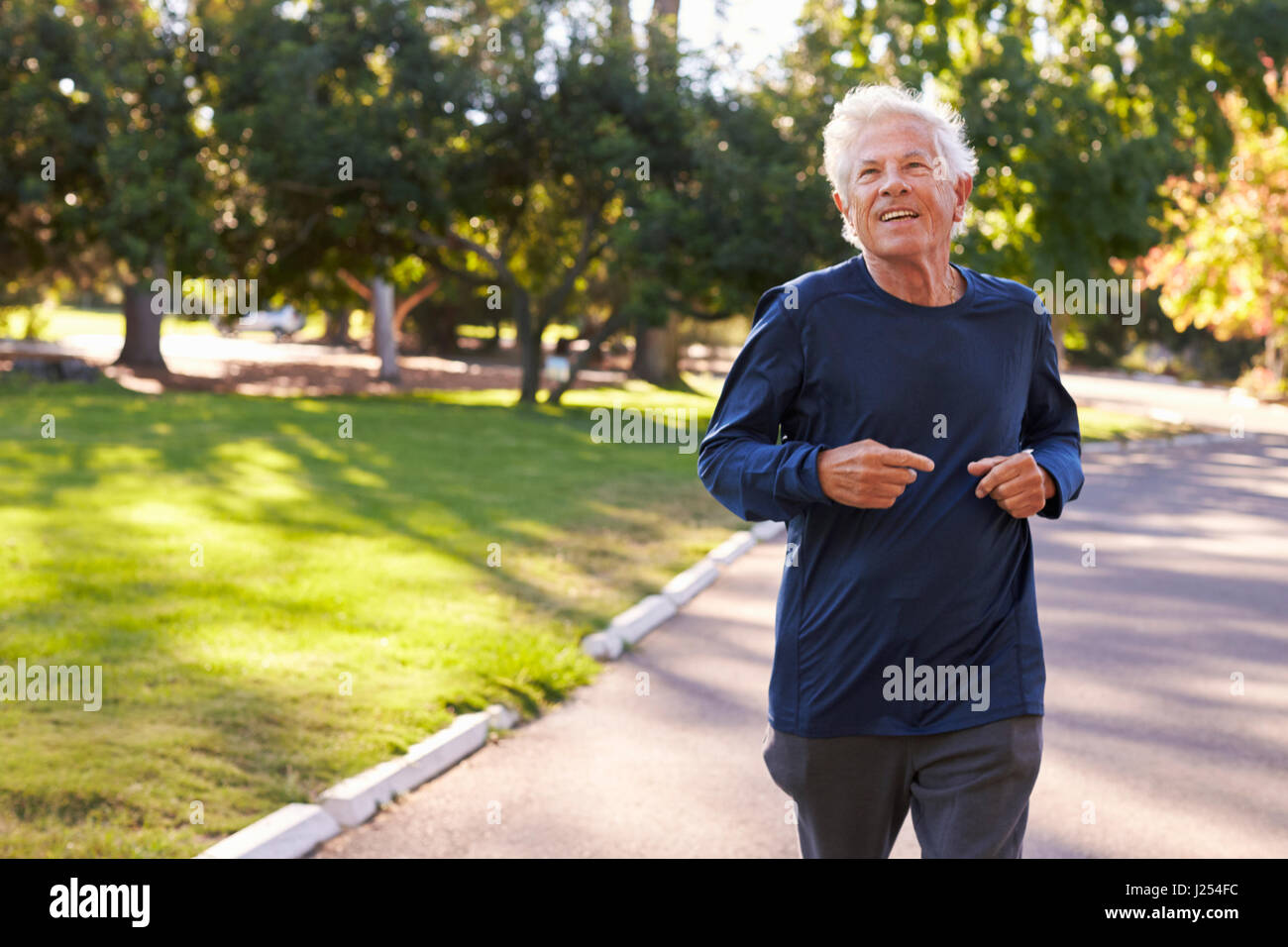 Front View Of Senior Man Jogging Through Park Stock Photo - Alamy