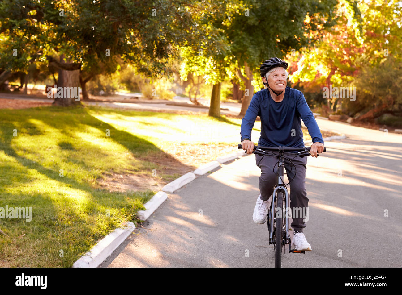 Front View Of Senior Man Cycling Through Park Stock Photo - Alamy