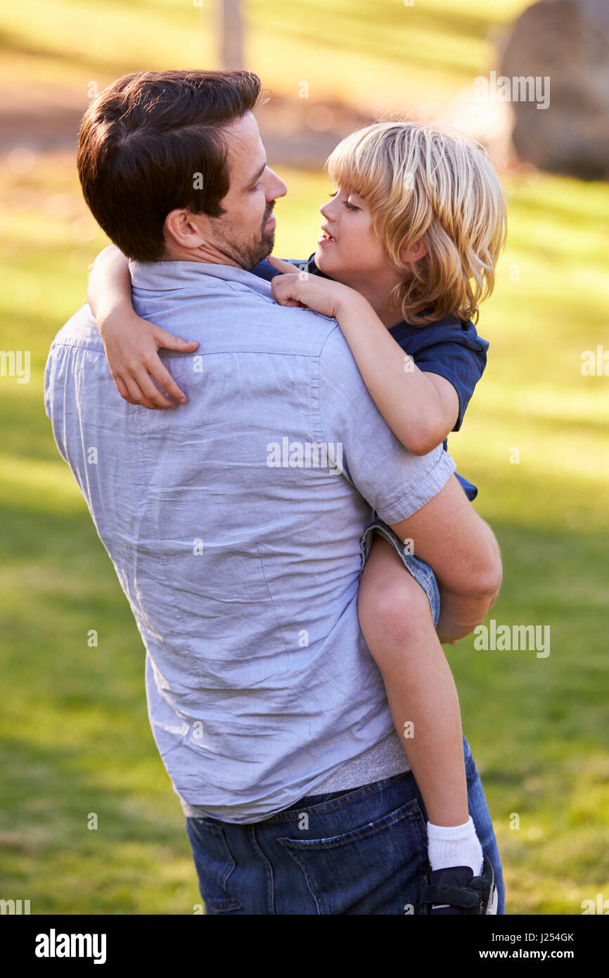 Loving Father Hugging Son In Park Stock Photo - Alamy