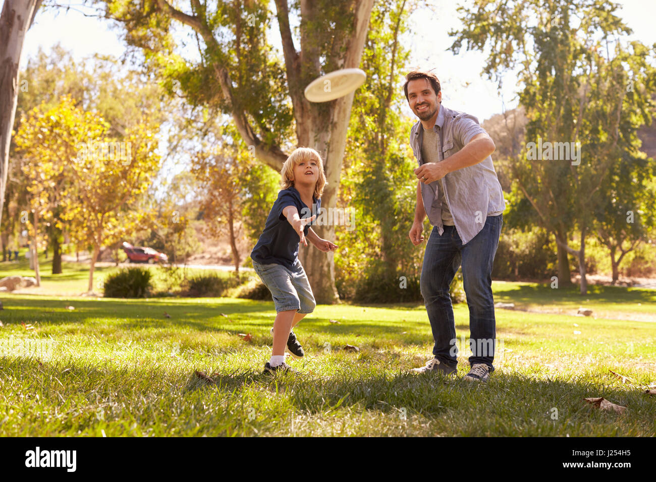 Father Teaching Son To Throw Frisbee In Park Stock Photo - Alamy