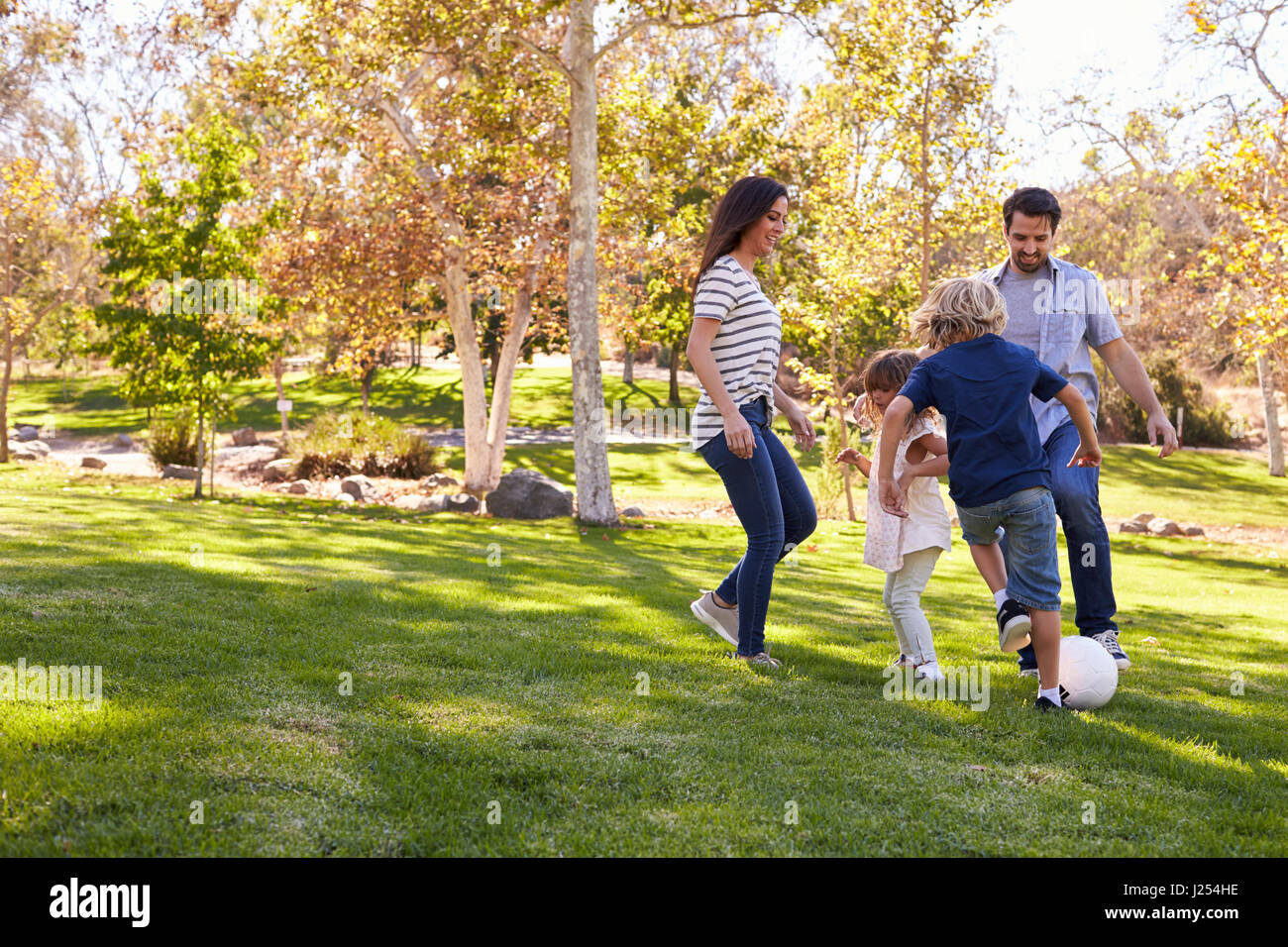Family Playing Soccer In Park Together Stock Photo - Alamy