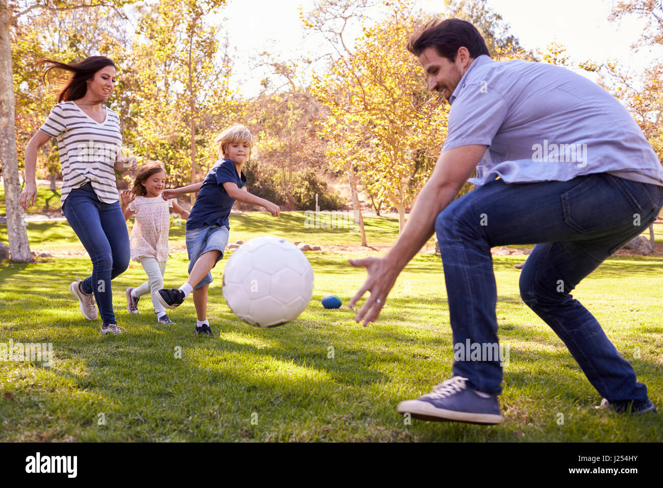 Family Playing Soccer In Park Together Stock Photo - Alamy