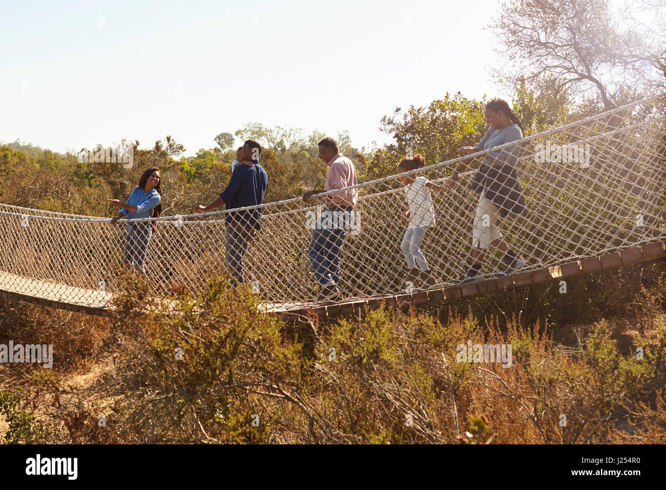 Multi Generation Family Crossing Rope Bridge Together Stock Photo - Alamy