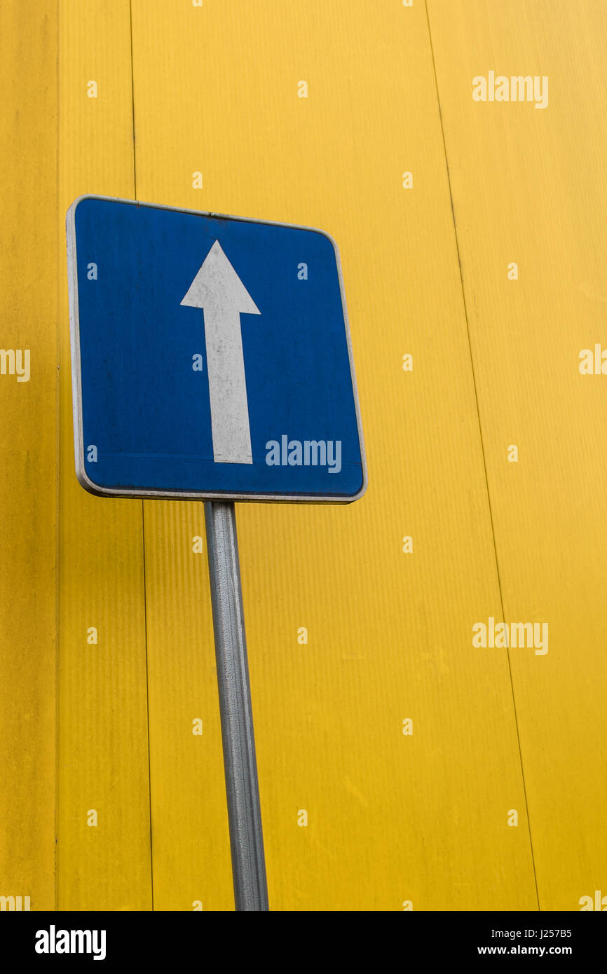 One-way street sign against yellow building wall Stock Photo - Alamy