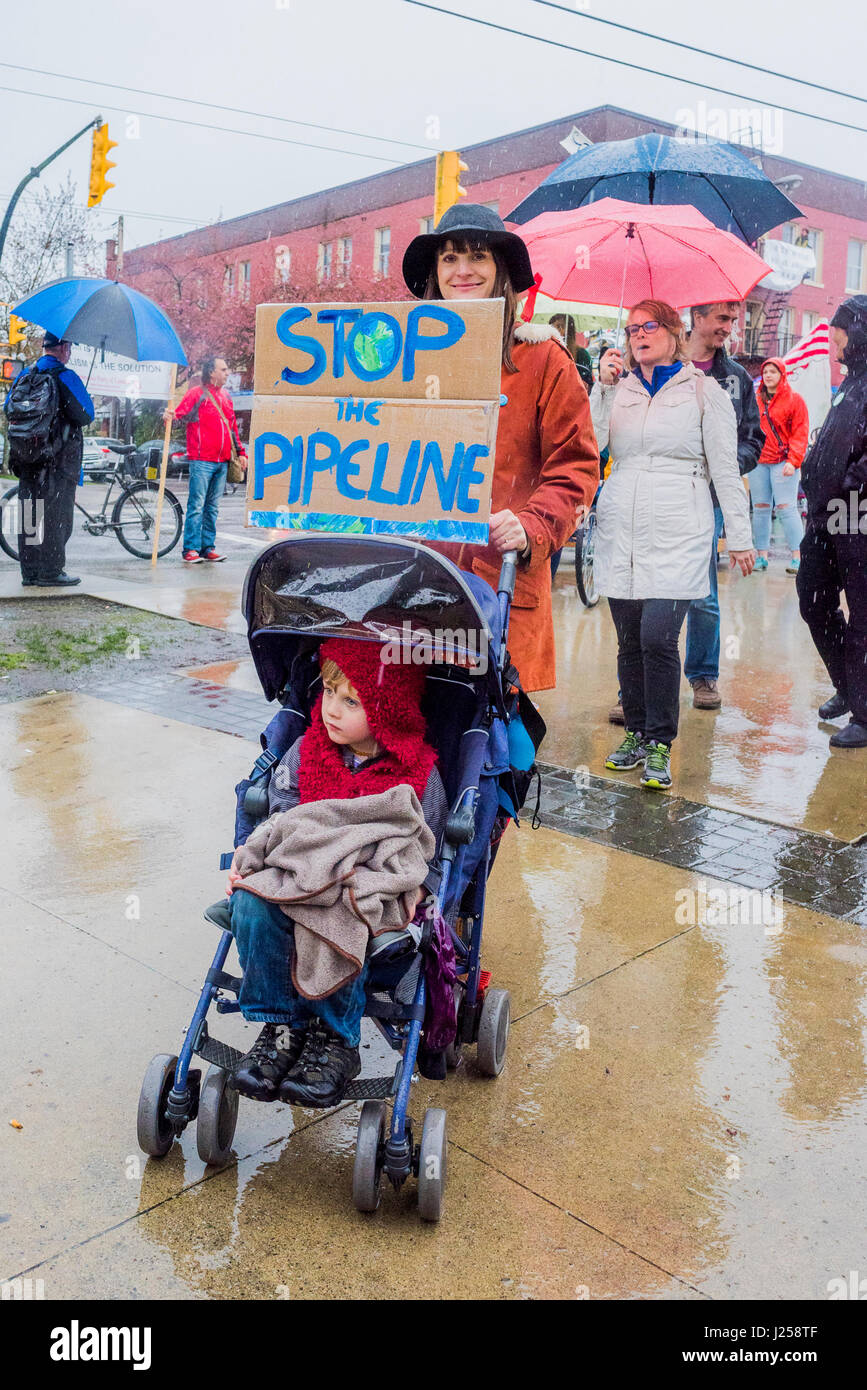 Woman with stop the pipeline sign at rainy Earth Day Parade and ...