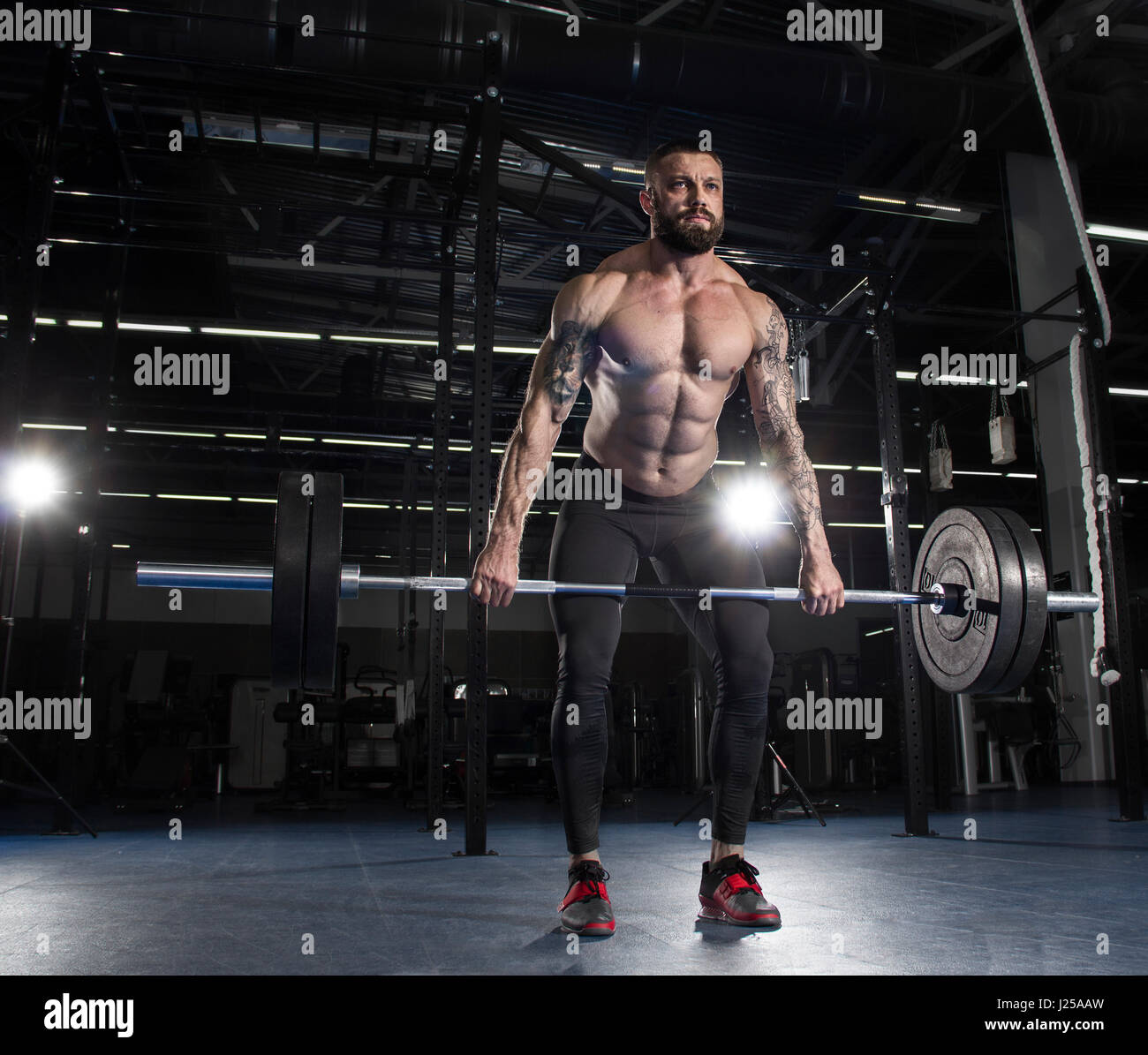 Attractive muscular bodybuilder doing deadlifts in modern gym.Clean and ...